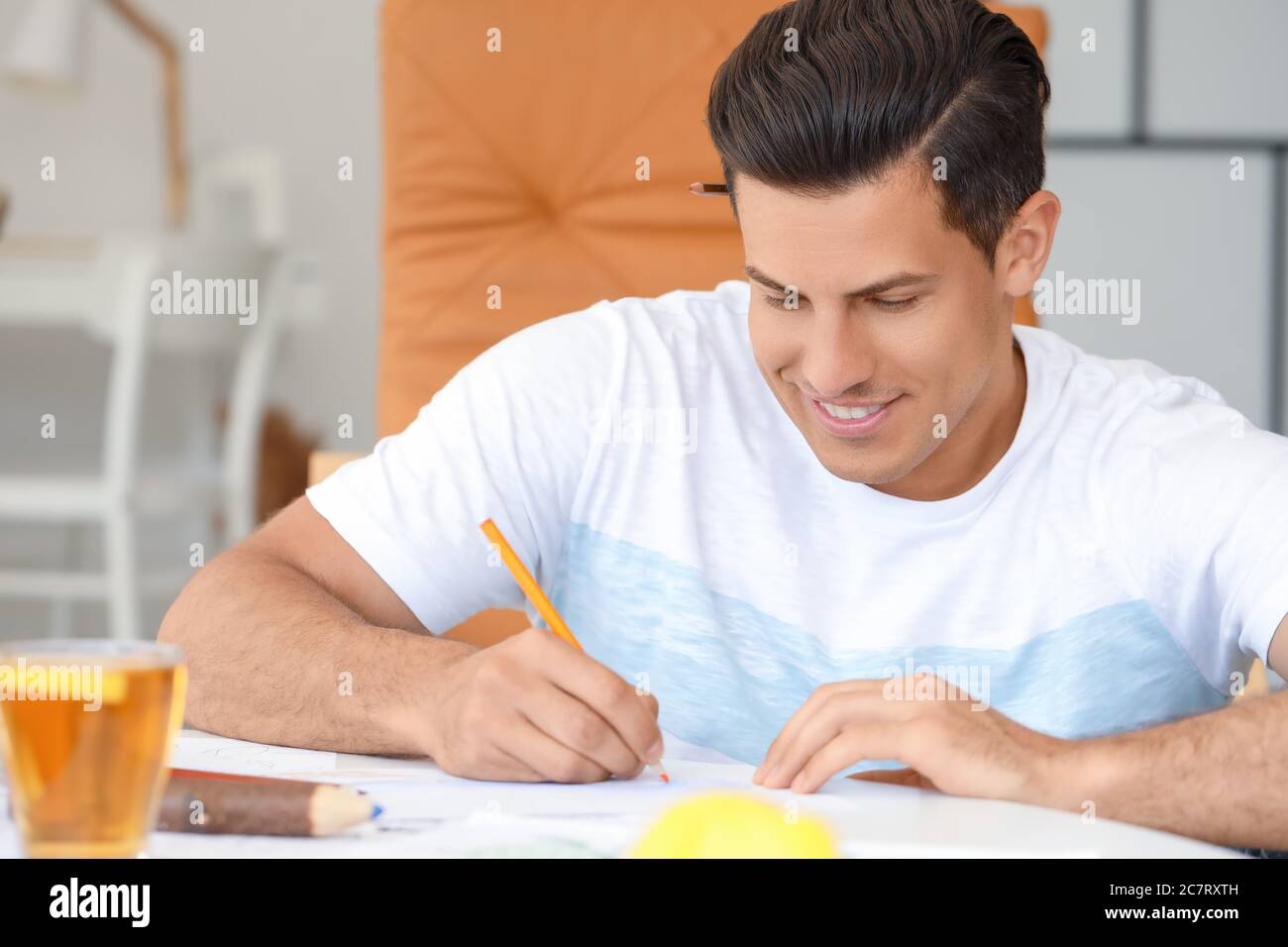 Young man coloring pictures at home Stock Photo - Alamy