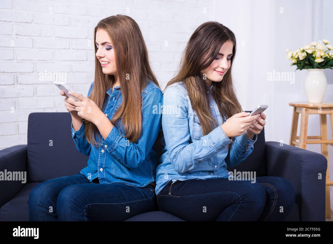 relationship and phone addiction concept - two girls using their smart ...