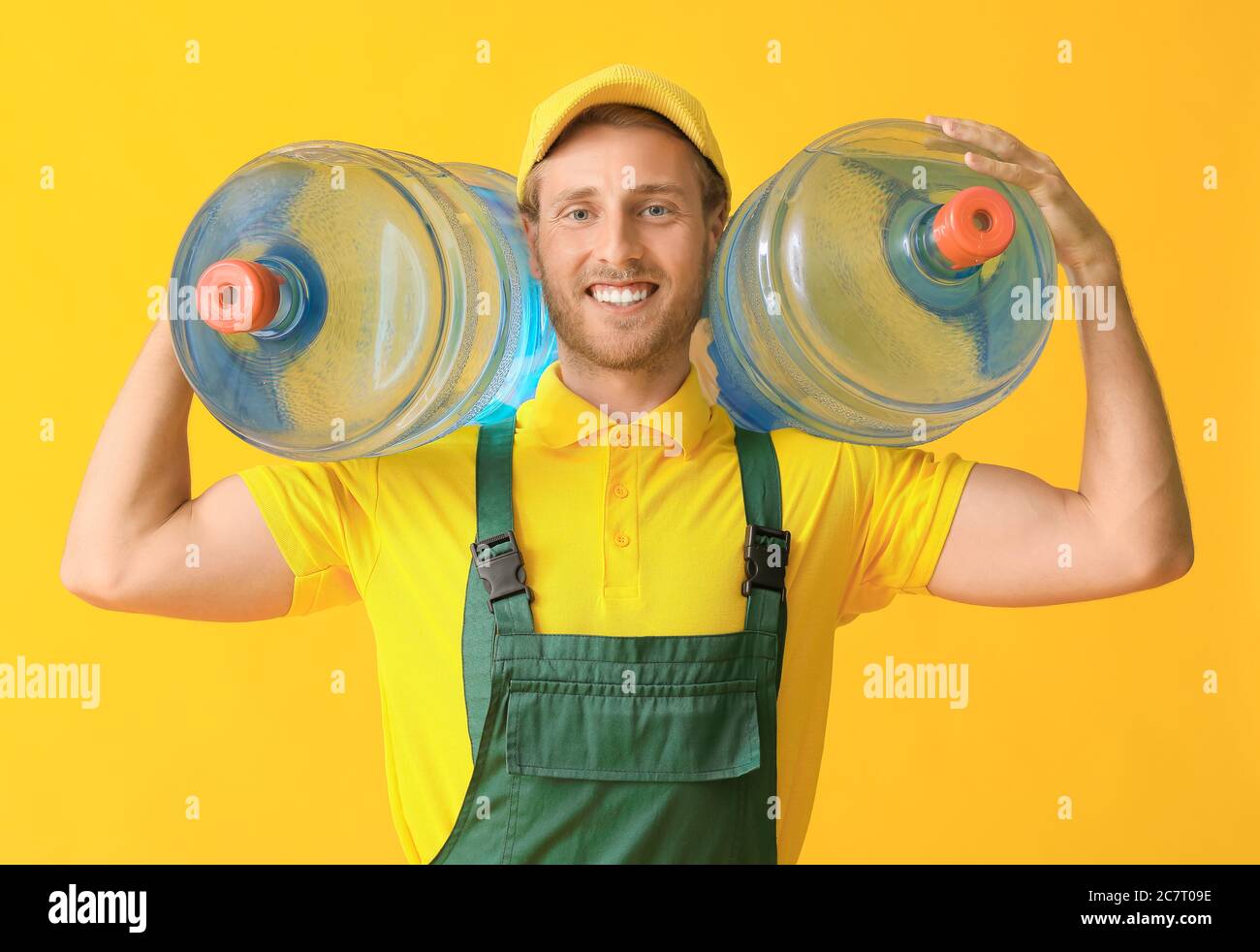 Delivery man with bottles of water on color background Stock Photo - Alamy