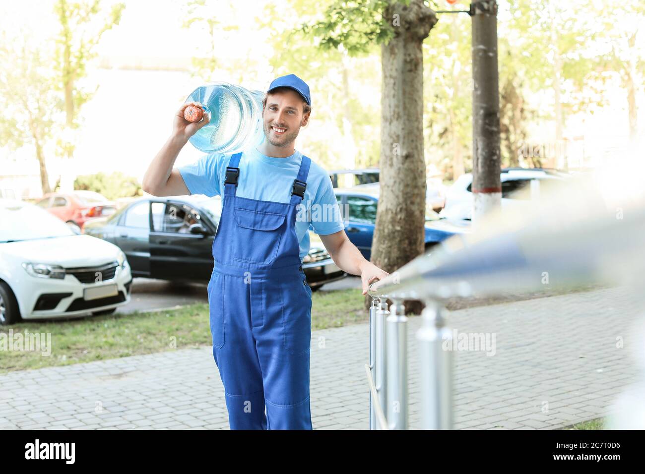 Delivery man with bottle of water outdoors Stock Photo - Alamy