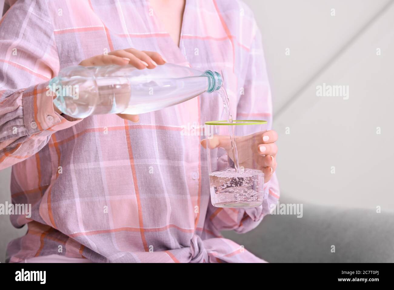Woman pouring water into glass at home Stock Photo - Alamy