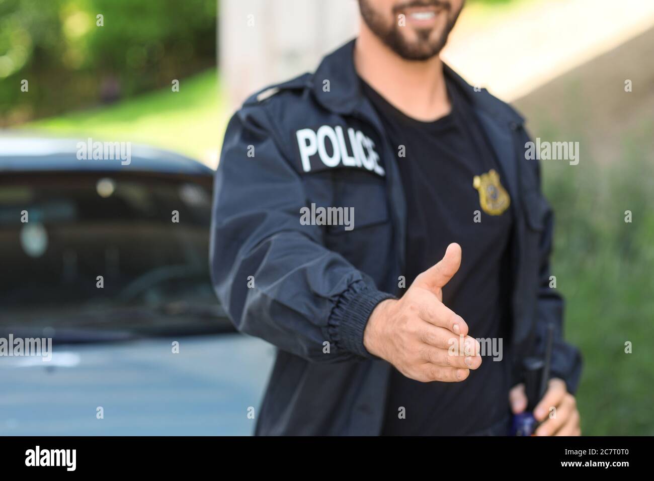 Handsome male police officer giving hand for handshake outdoors Stock ...