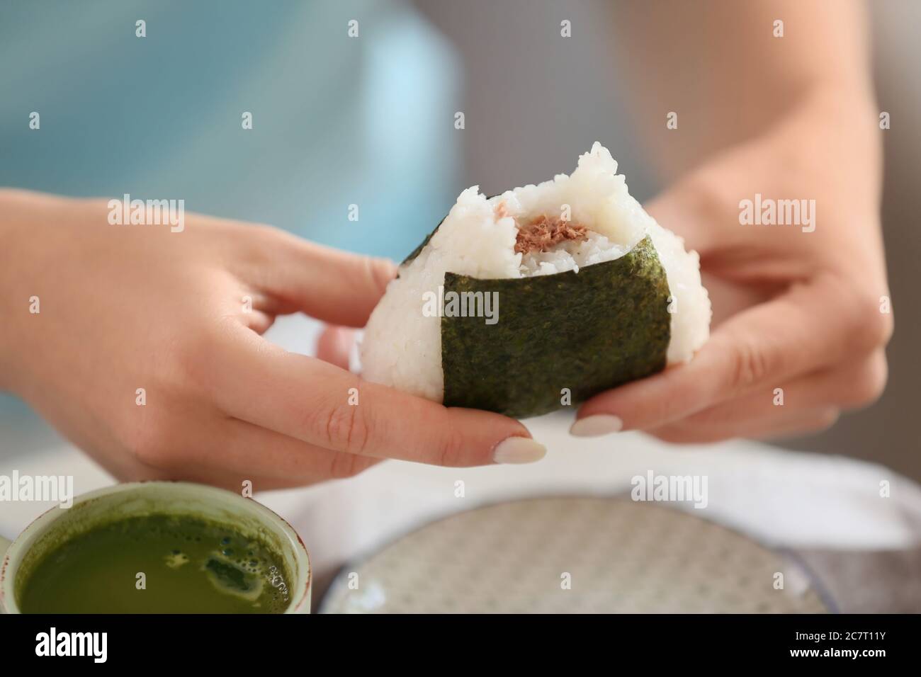 Woman eating traditional Japanese onigiri, closeup Stock Photo - Alamy