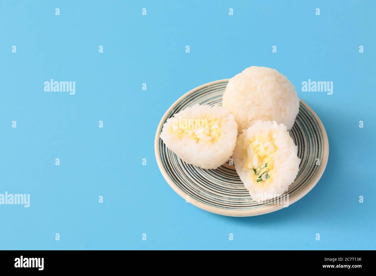 Plate with traditional Japanese onigiri on color background Stock Photo ...
