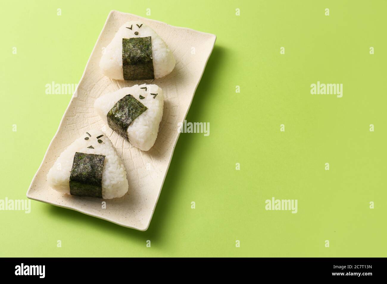 Plate with traditional Japanese onigiri on color background Stock Photo ...
