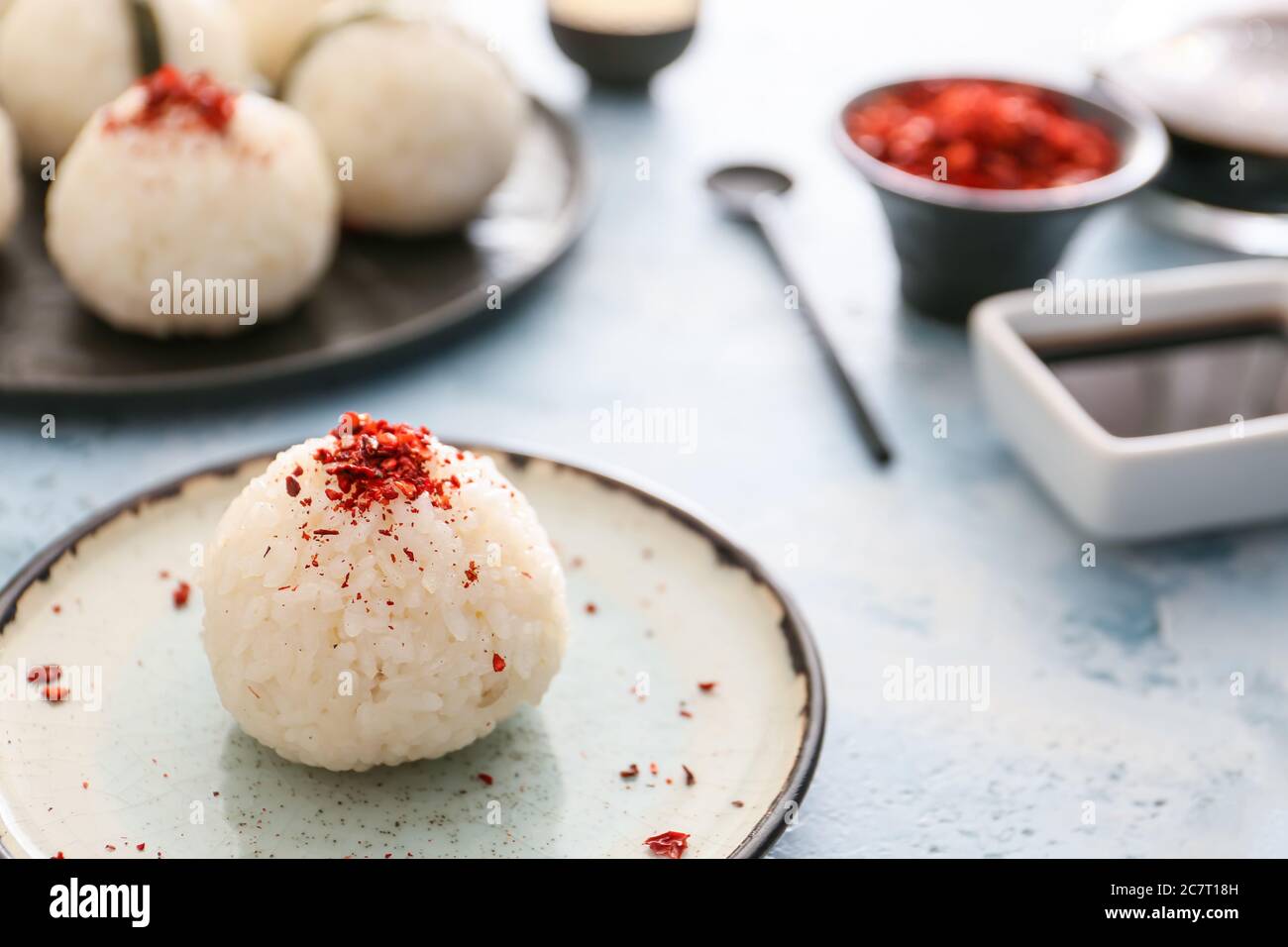 Plate with traditional Japanese onigiri with spices on color background ...