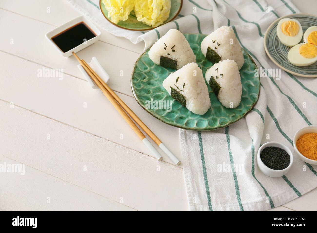 Plate with traditional Japanese onigiri and ingredients on table Stock ...