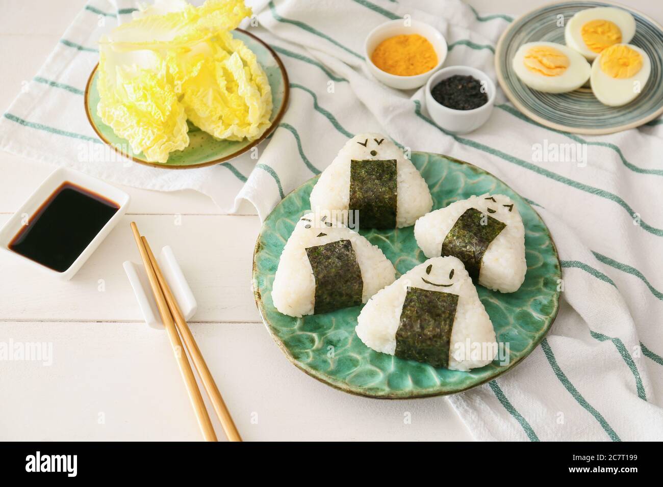 Plate with traditional Japanese onigiri and ingredients on table Stock ...