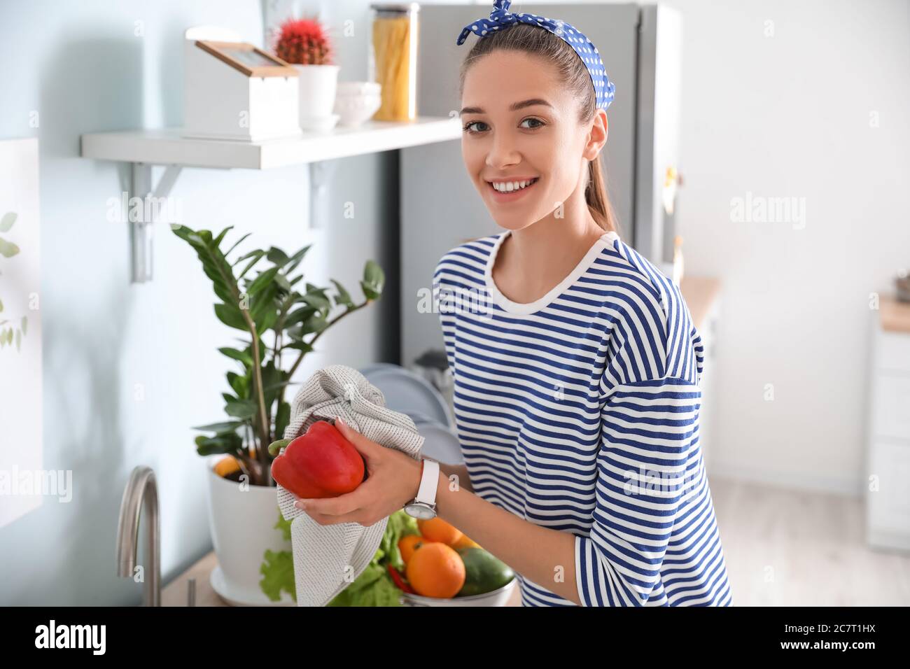 Beautiful young woman washing fresh vegetables in kitchen Stock Photo ...