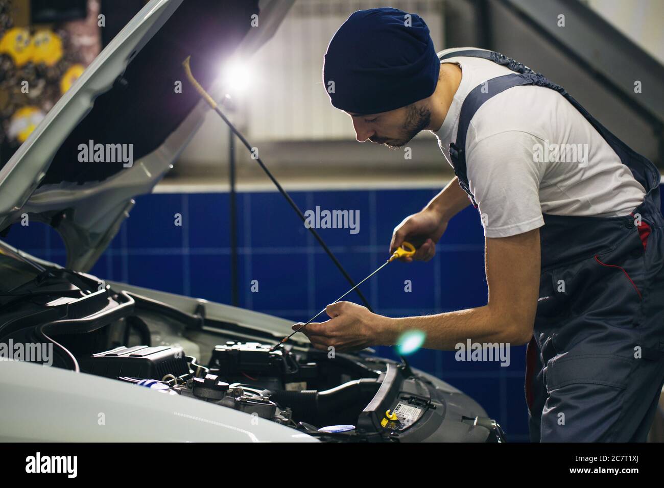 Auto mechanic is changing motor oil into a engine at car station Stock ...