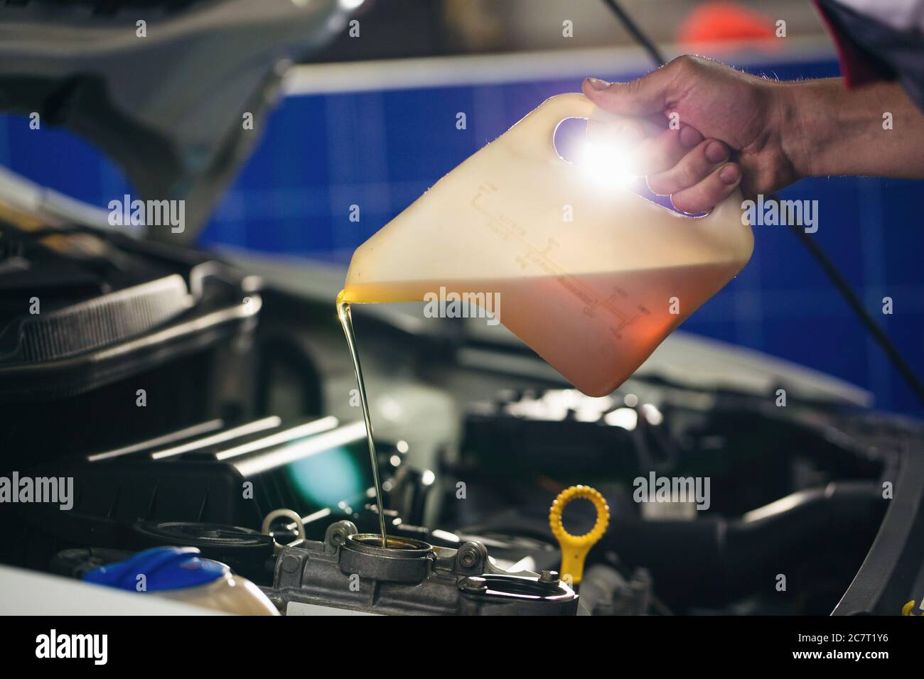 Auto mechanic is changing motor oil into a engine at car station Stock ...