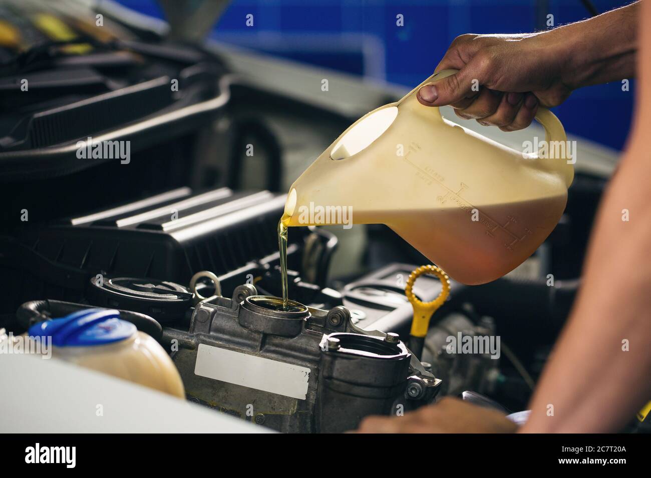 Auto mechanic is changing motor oil into a engine at car station Stock ...