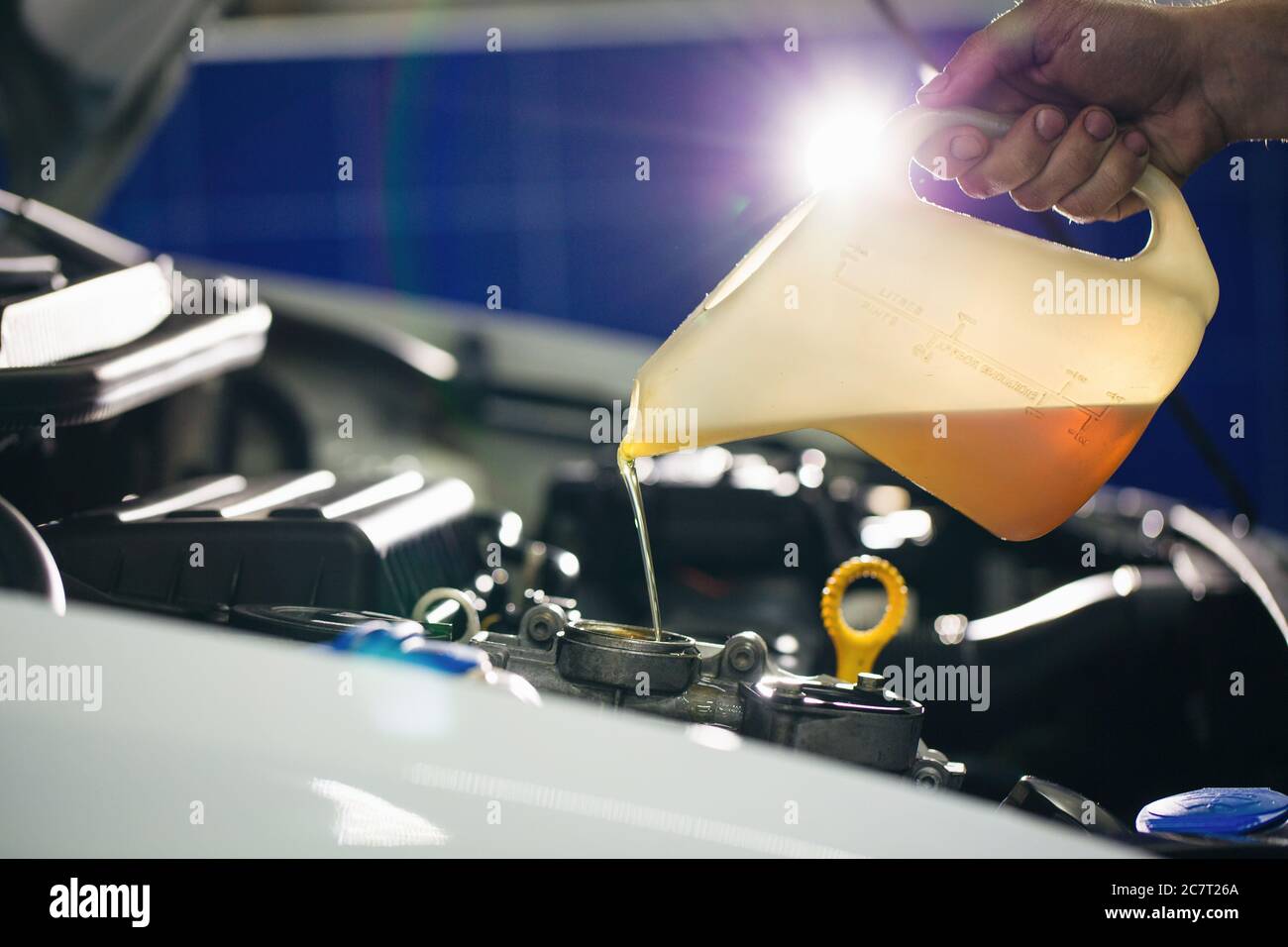 Auto mechanic is changing motor oil into a engine at car station Stock ...