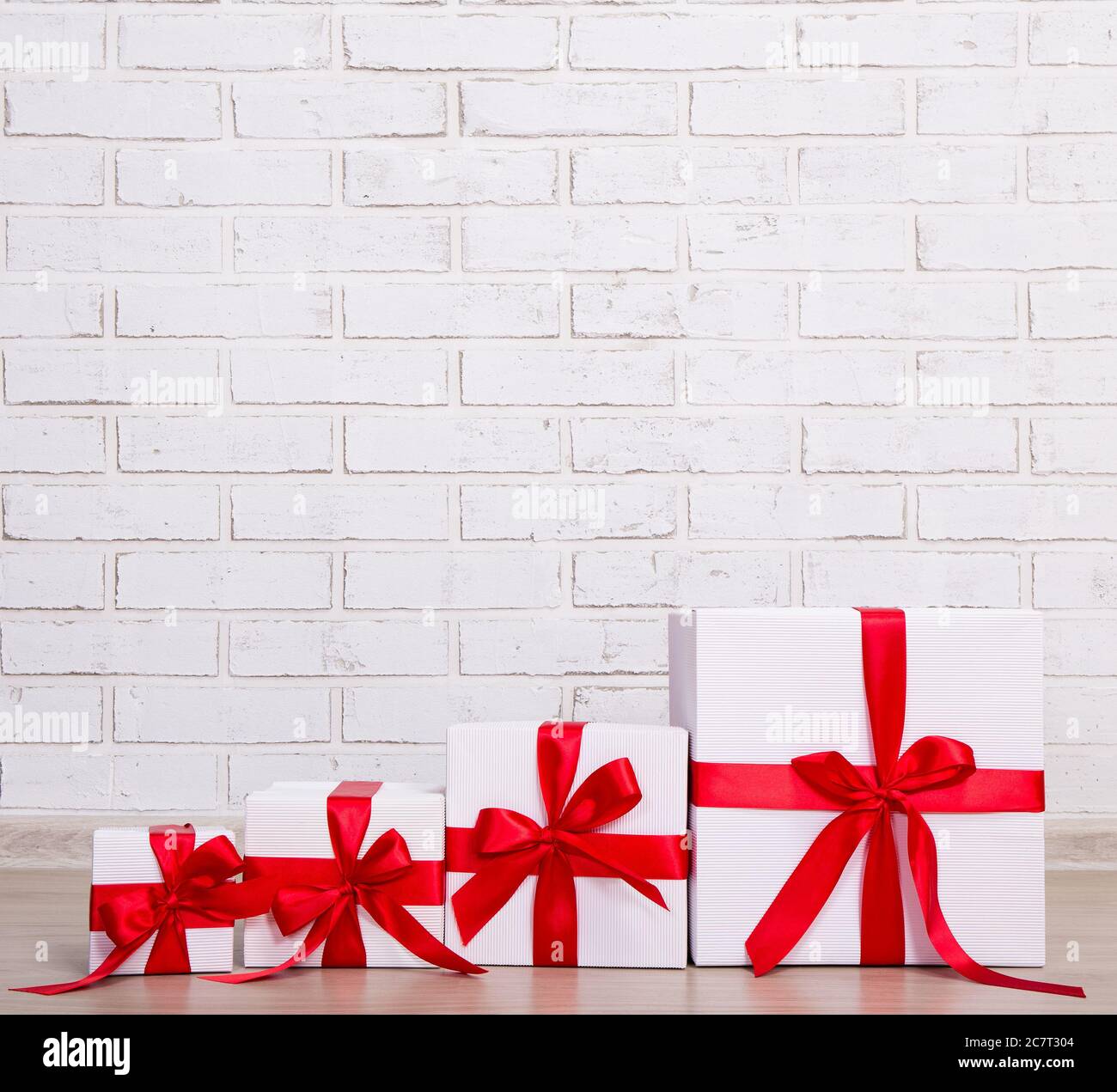 christmas background - gift boxes over white brick wall Stock Photo - Alamy