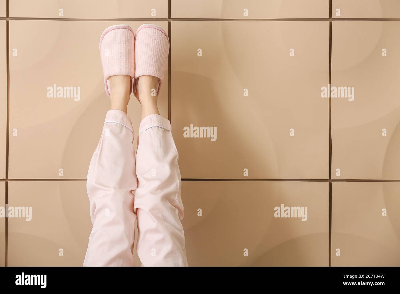 Female legs in soft slippers on color background Stock Photo - Alamy
