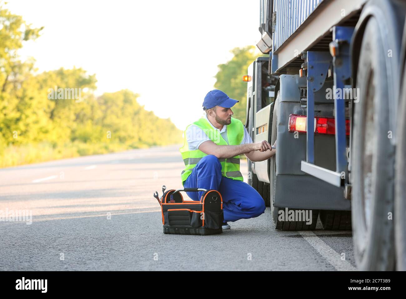 Male driver fixing big truck outdoors Stock Photo - Alamy
