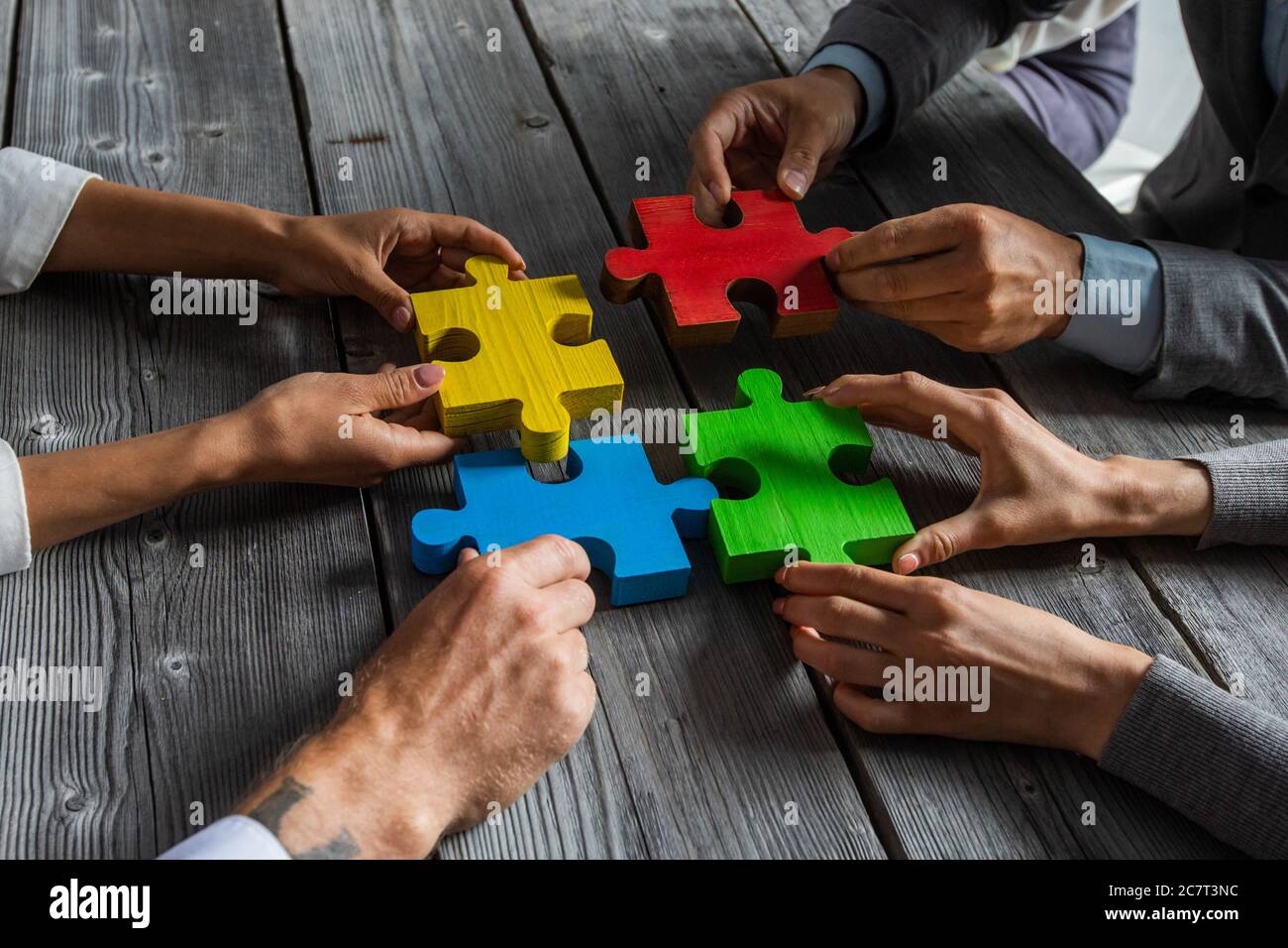 Business people team sitting around meeting table and assembling color ...