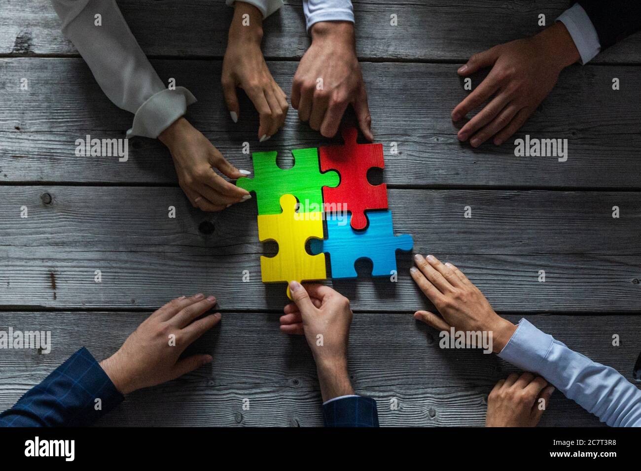 Business people team sitting around meeting table and assembling color ...