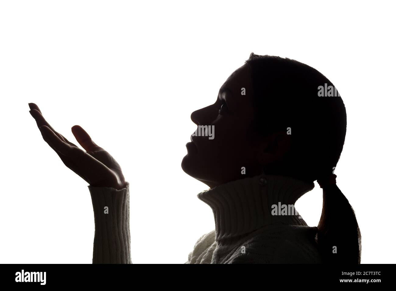 Young woman looking up with hope and request - horizontal silhouette of ...