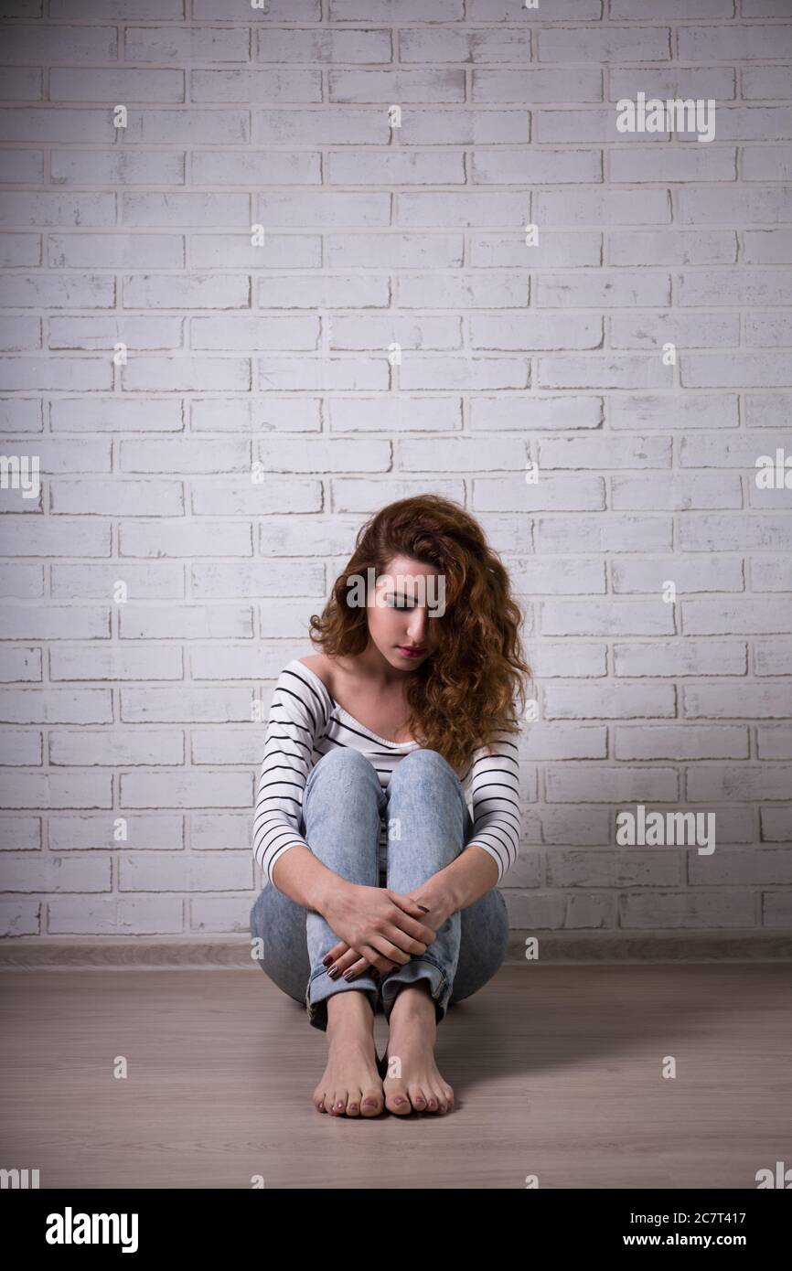 depression and loneliness - sad young woman sitting on the floor over ...