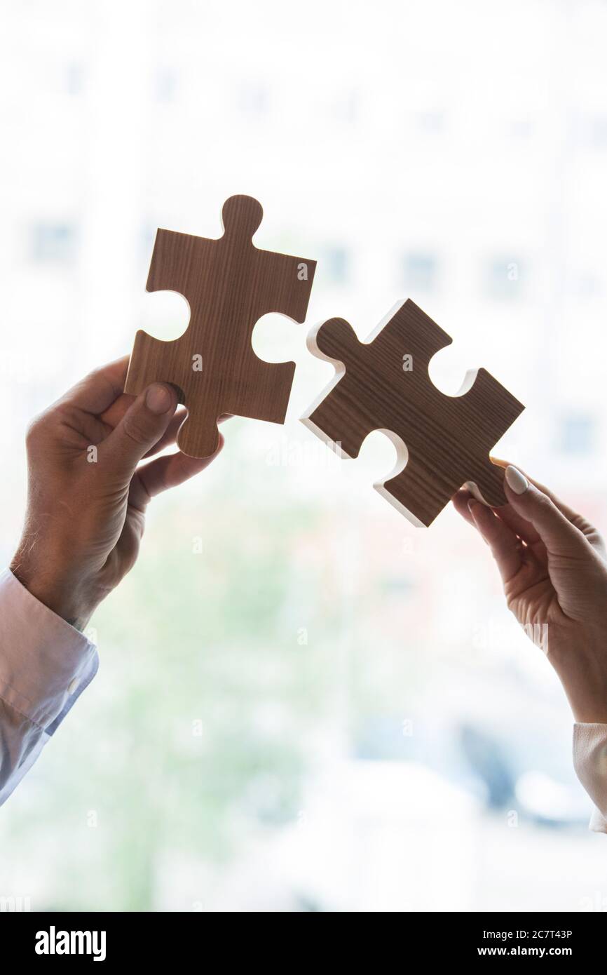 Male and female hands with puzzle pieces on white, business cooperation ...