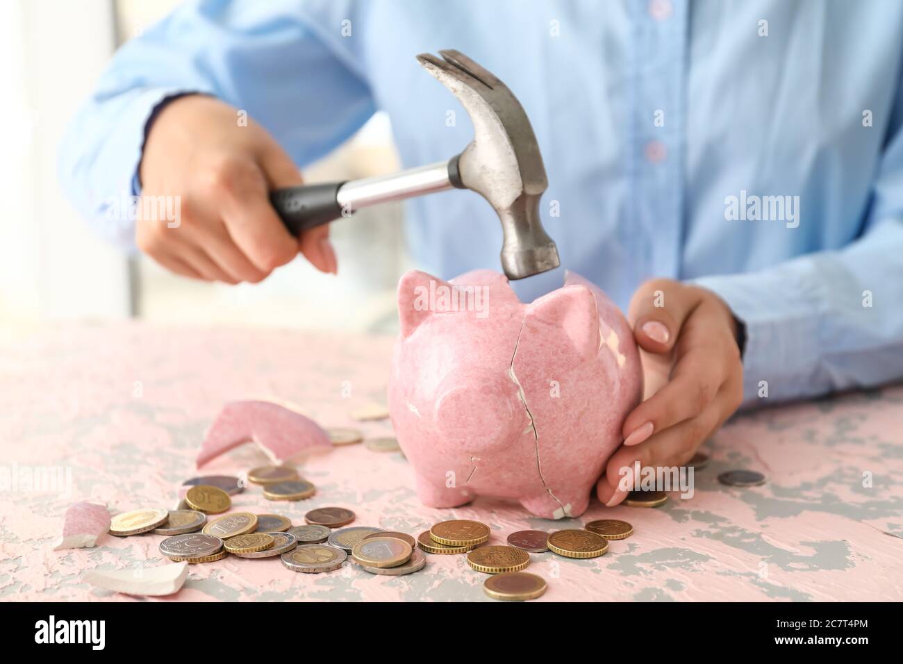 Female breaking piggy bank hi-res stock photography and images - Alamy