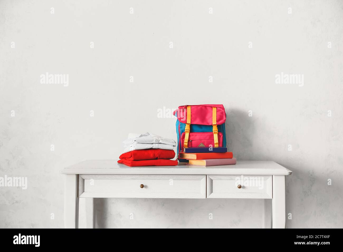 Stylish school uniform with books and backpack on table in room Stock ...
