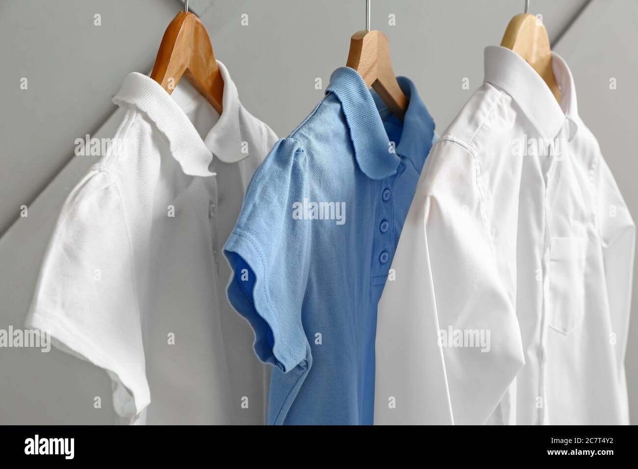 Rack with school uniform on grey background Stock Photo - Alamy