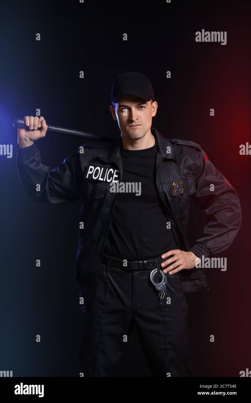 Aggressive police officer on dark background Stock Photo - Alamy