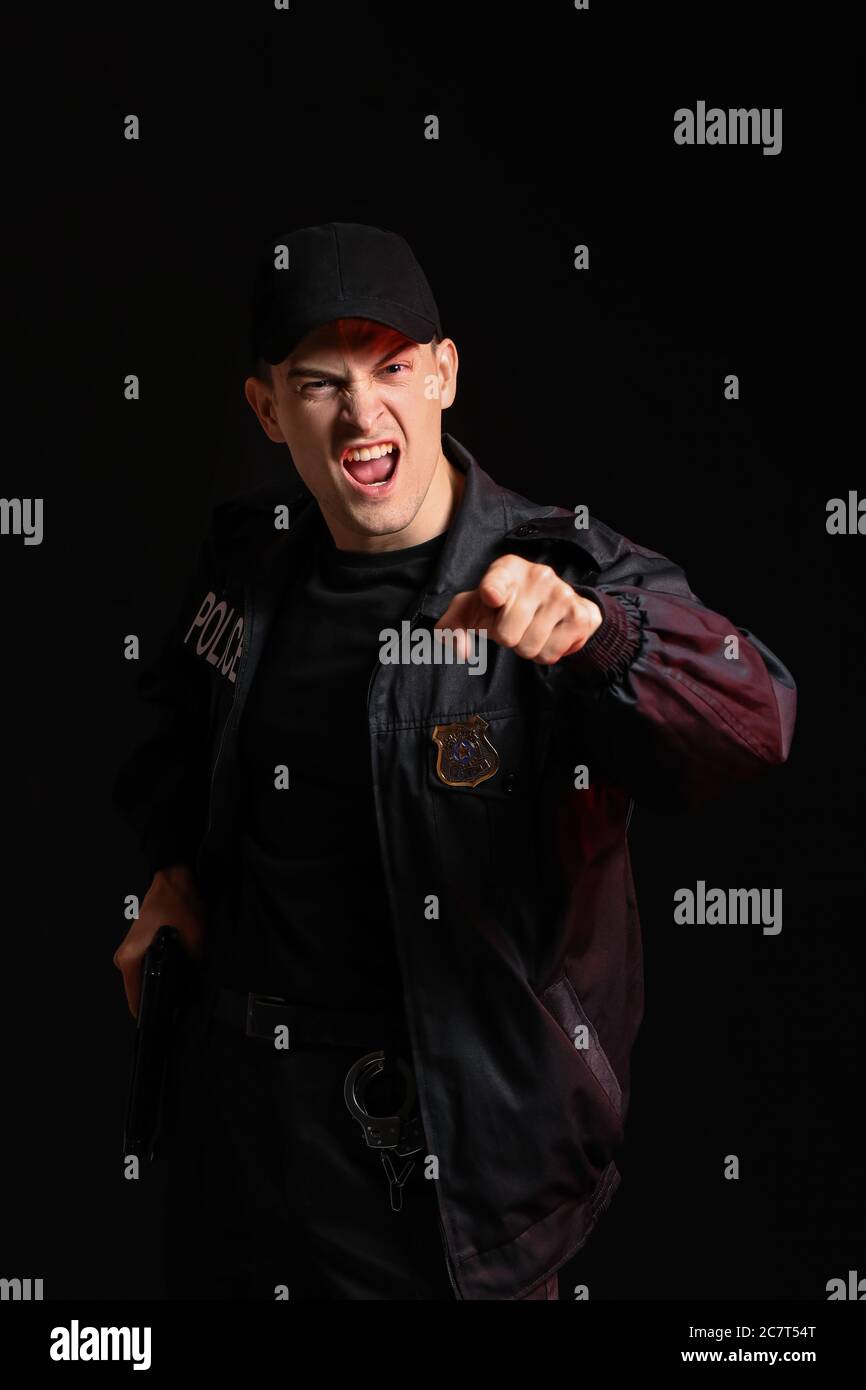 Aggressive police officer on dark background Stock Photo - Alamy