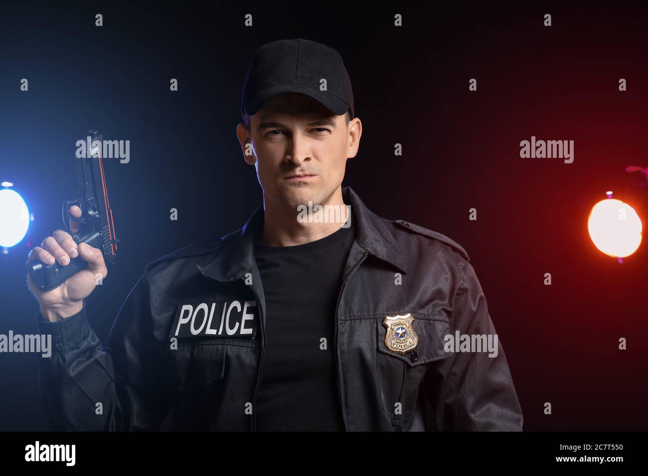 Aggressive police officer with gun on dark background Stock Photo - Alamy