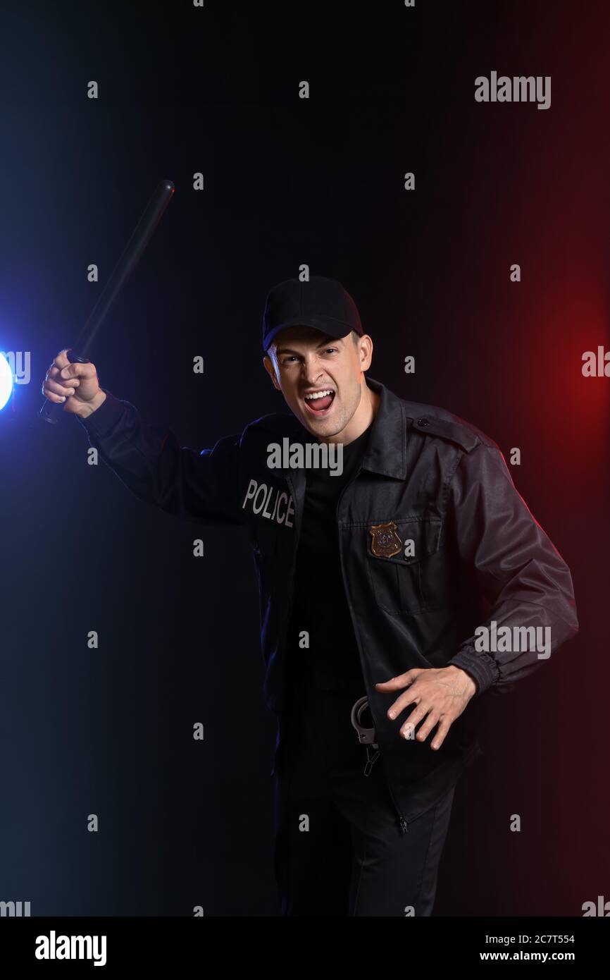 Aggressive police officer on dark background Stock Photo - Alamy