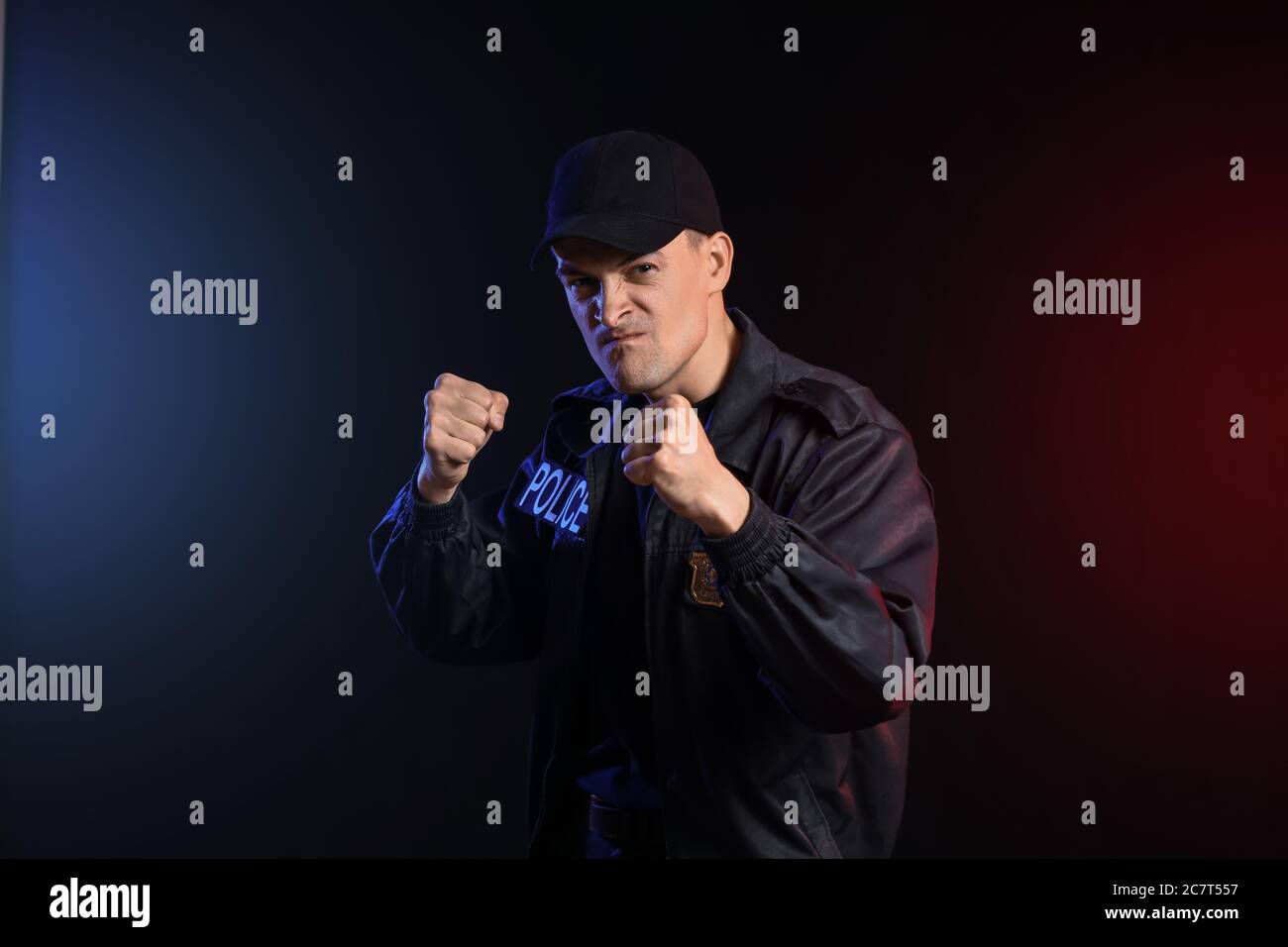 Aggressive police officer on dark background Stock Photo - Alamy