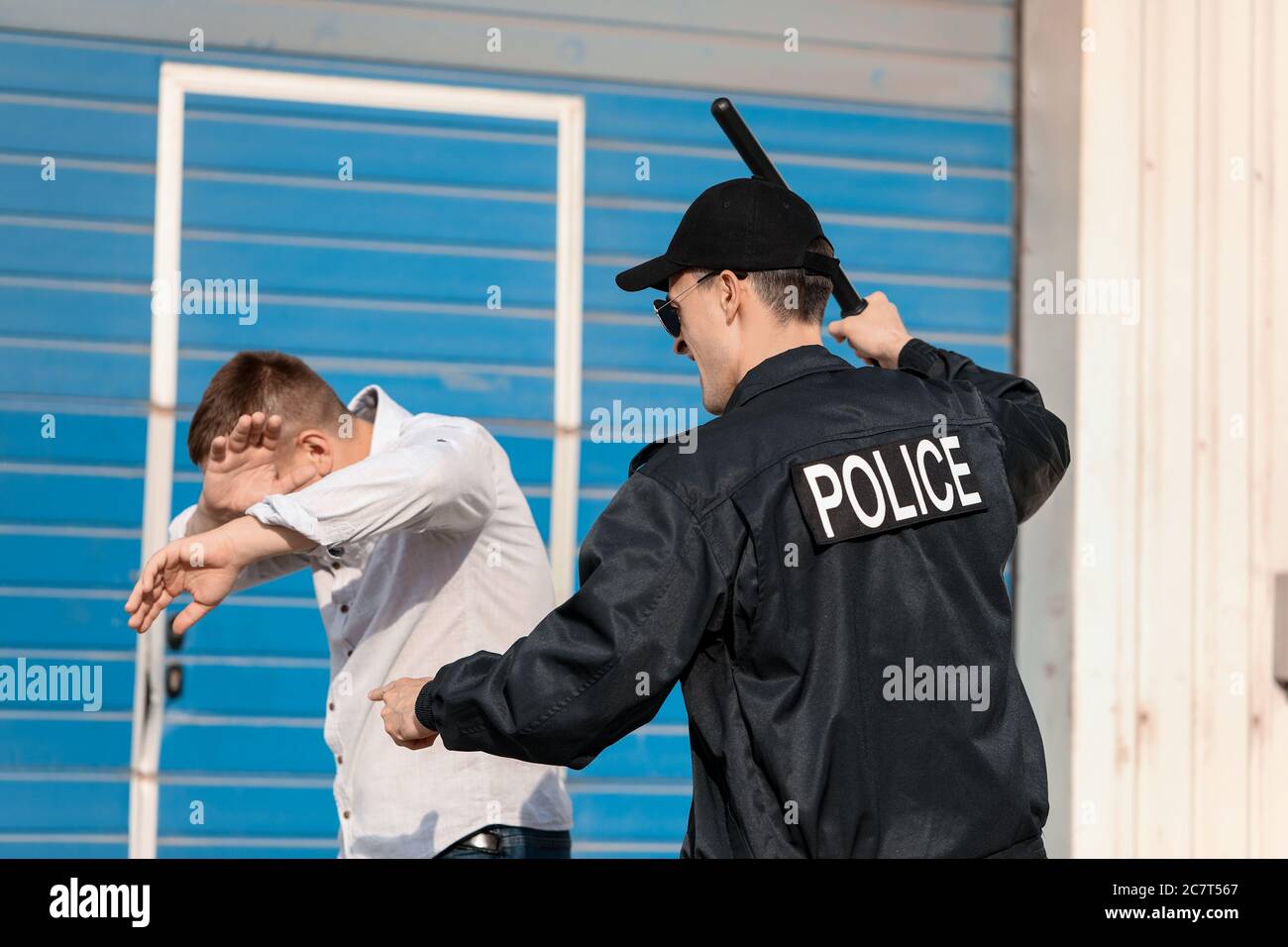 Aggressive police officer mistreating man outdoors Stock Photo - Alamy
