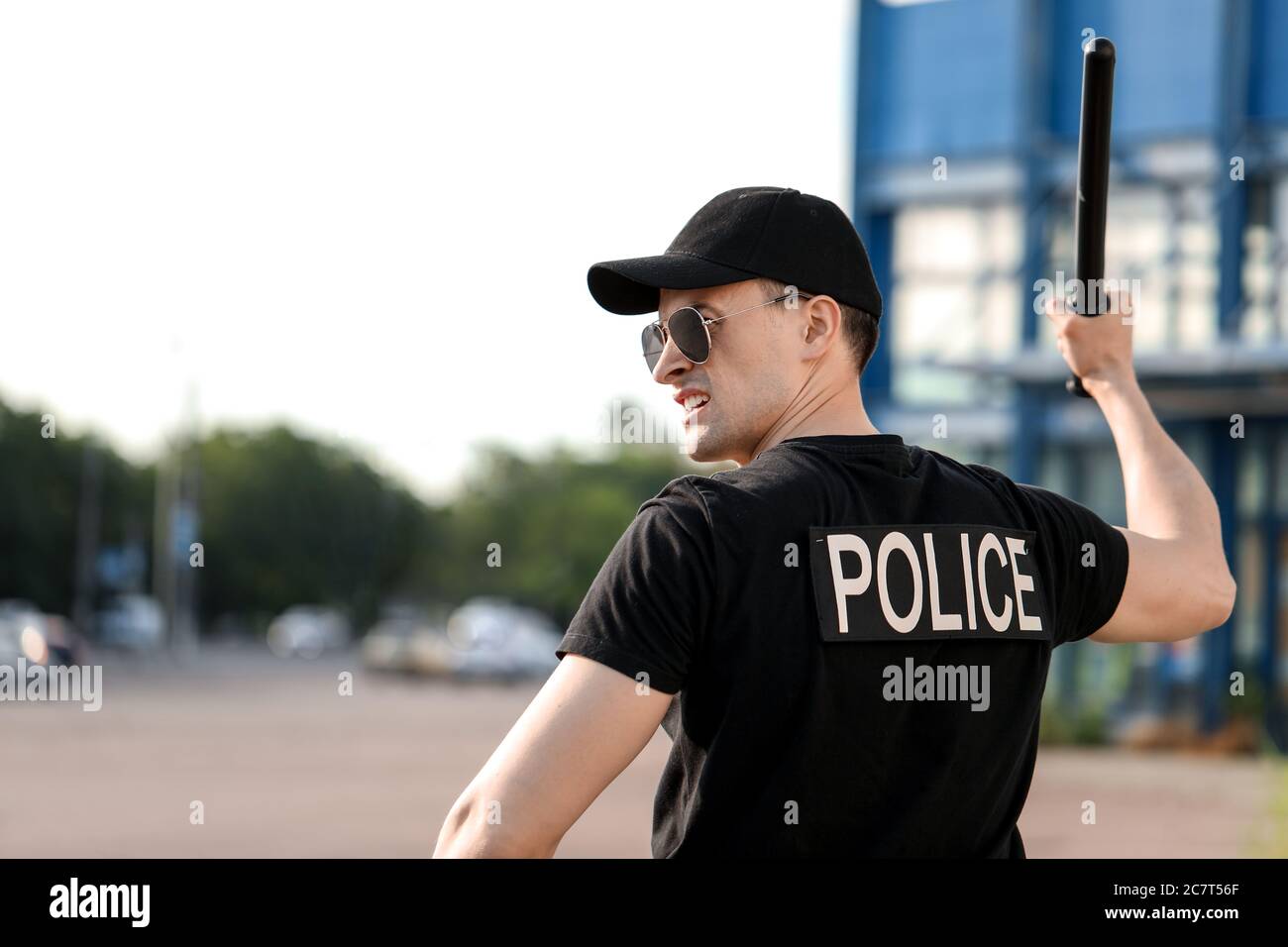 Aggressive police officer with baton outdoors Stock Photo - Alamy
