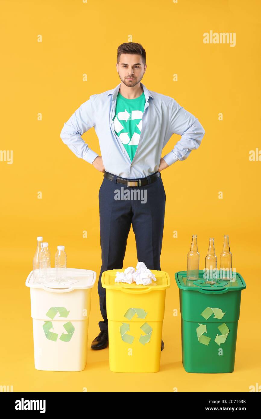 Man in t-shirt with recycling sign and trash bins on color background ...