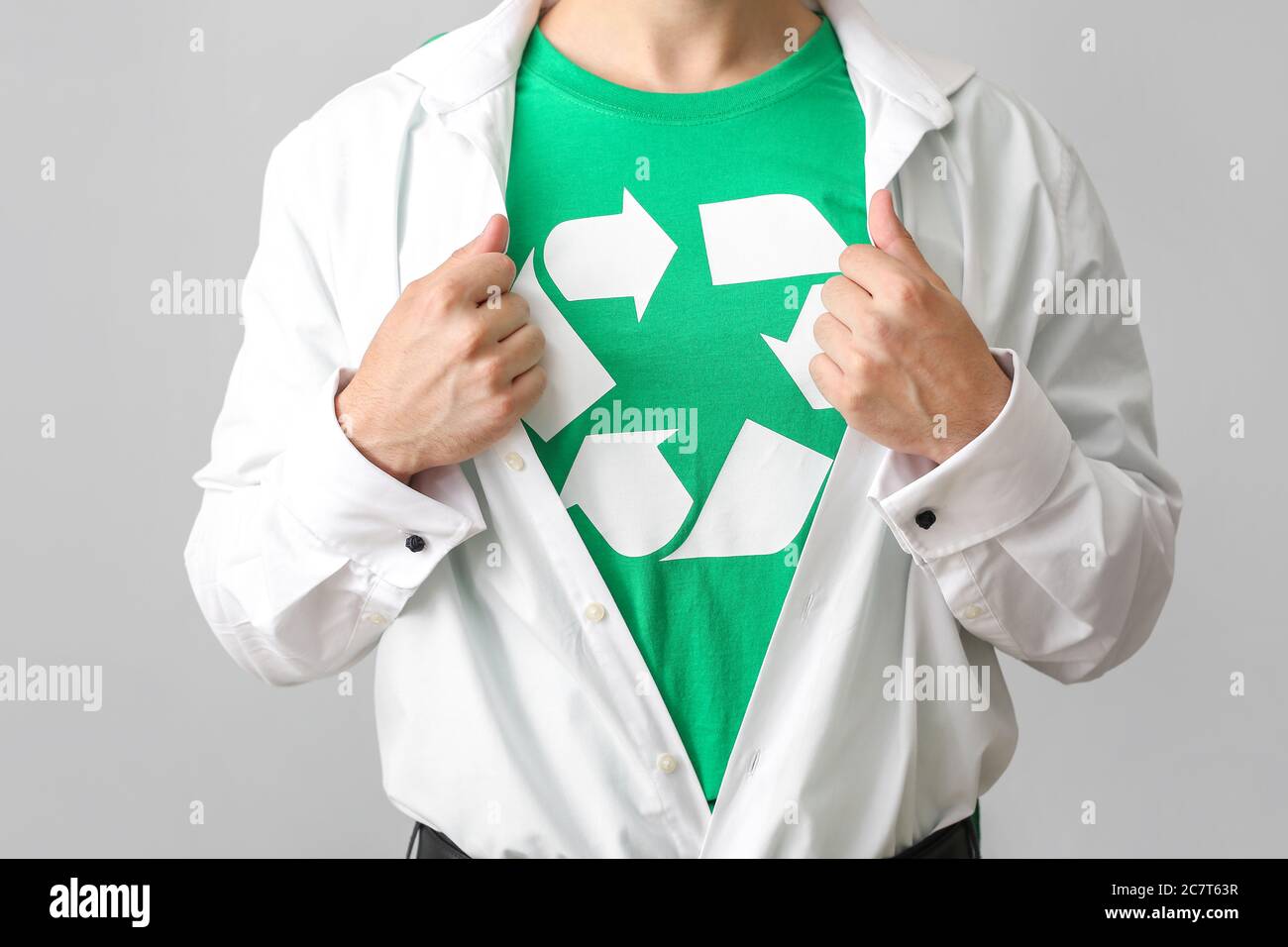 Man wearing t-shirt with recycling sign on grey background. Ecology ...