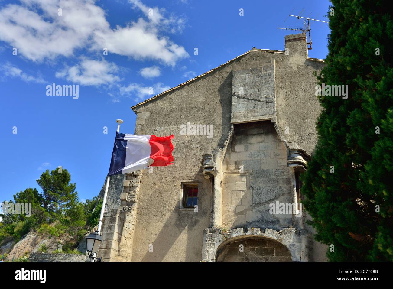 French flag in front of ancient building in one of the most picturesque ...