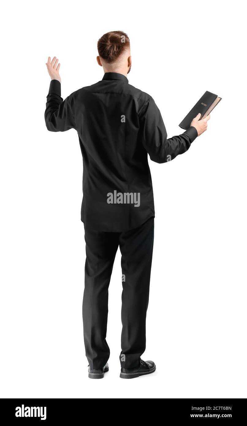 Handsome young priest with Bible on white background Stock Photo - Alamy