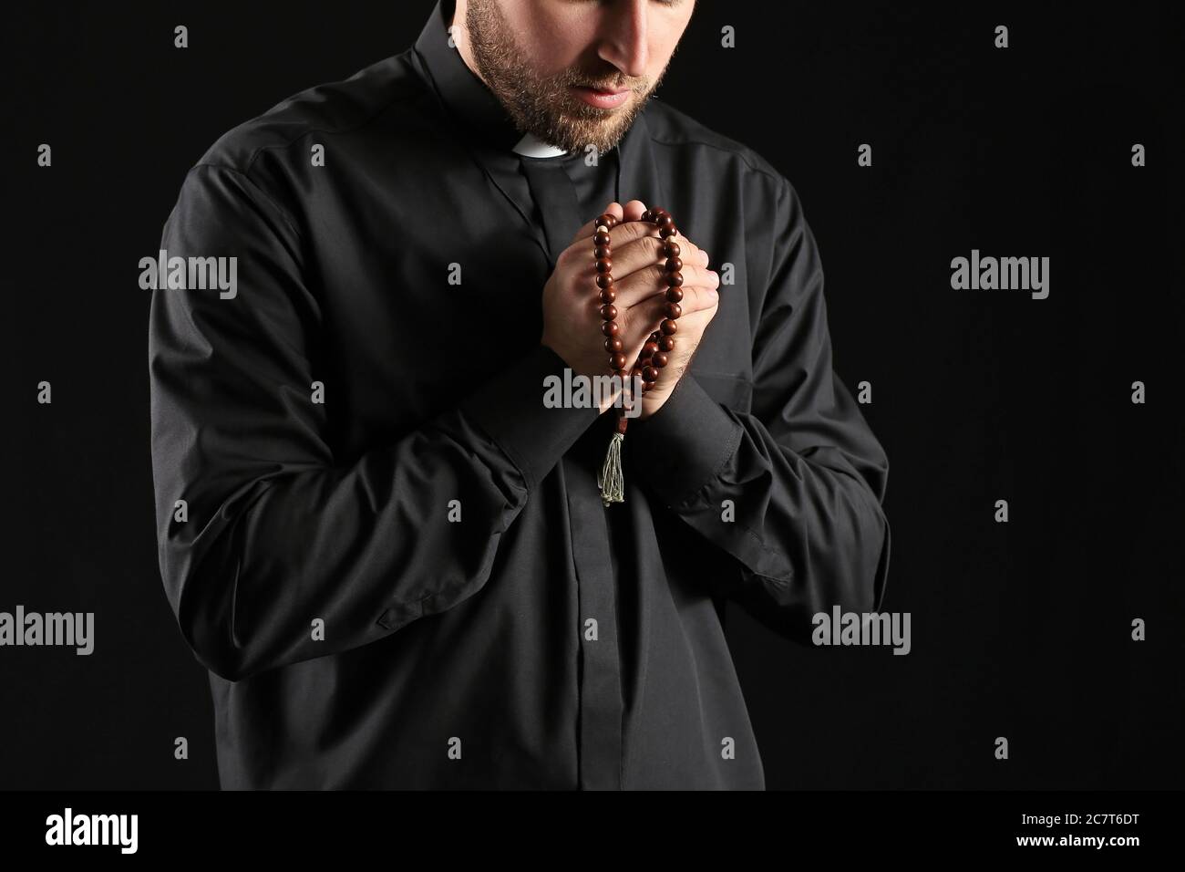 Young catholic priest praying rosary hi-res stock photography and ...
