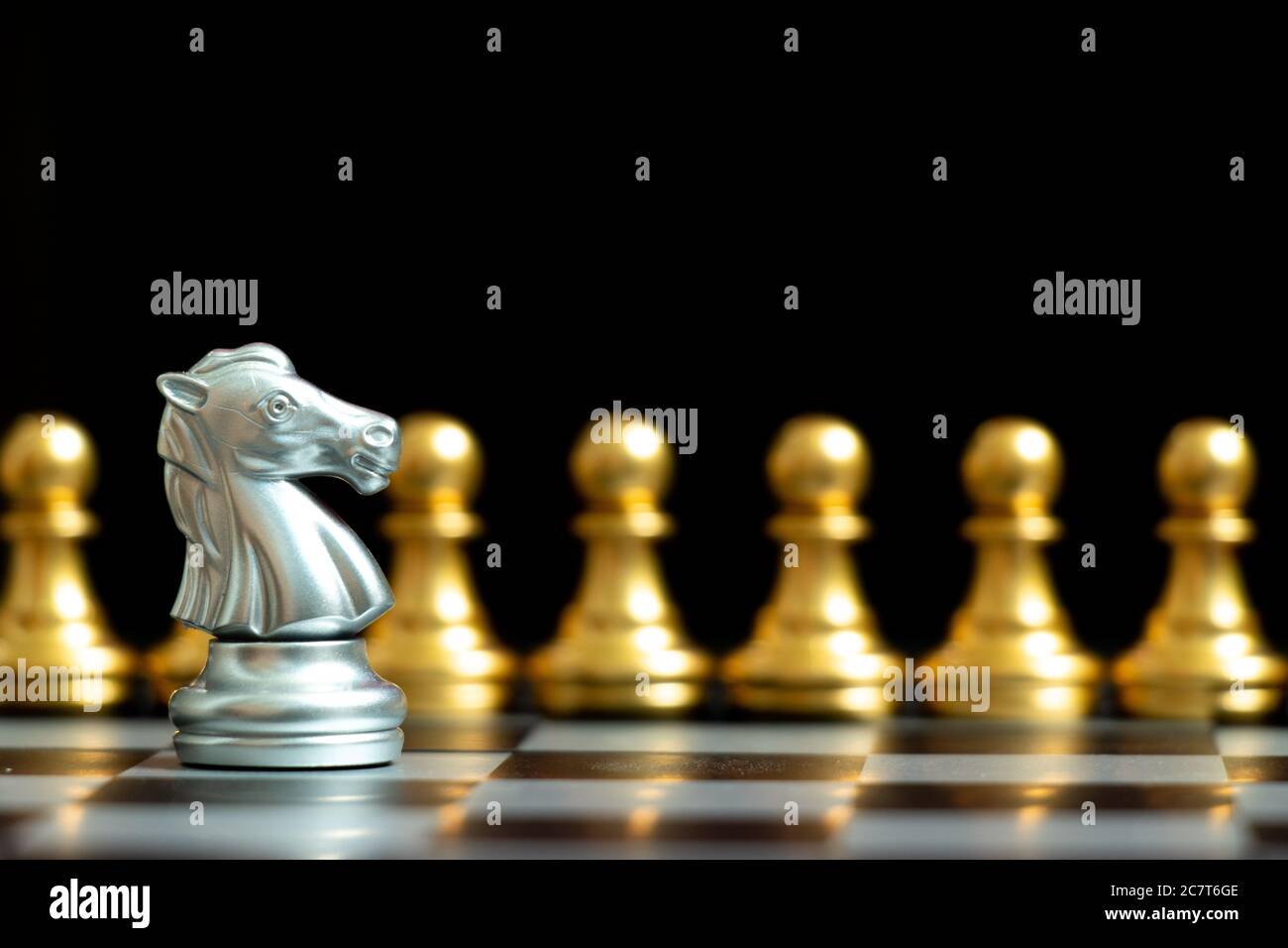 Silver knight chess piece face with gold team on black background ...