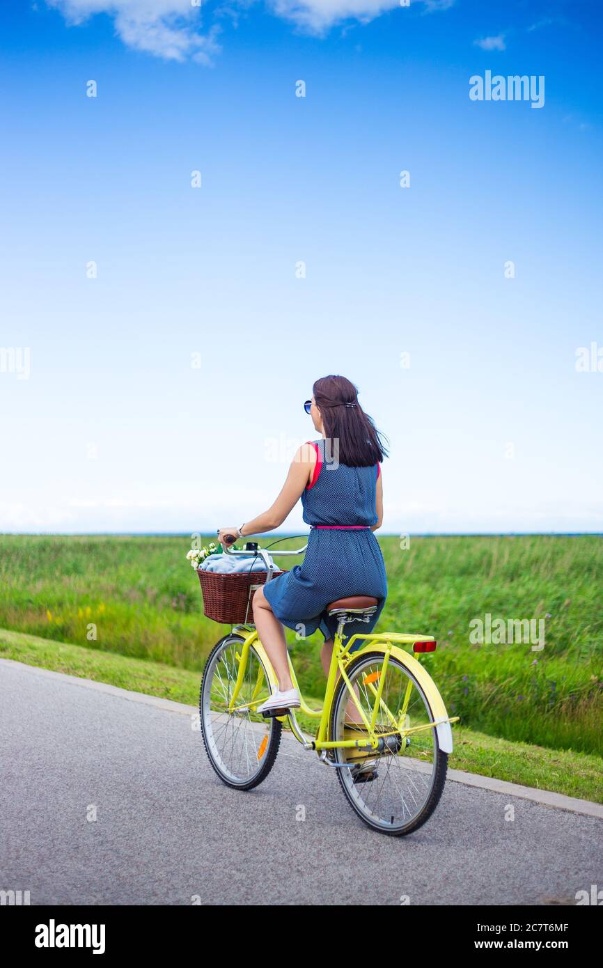 freedom concept - back view of woman riding retro bicycle in ...