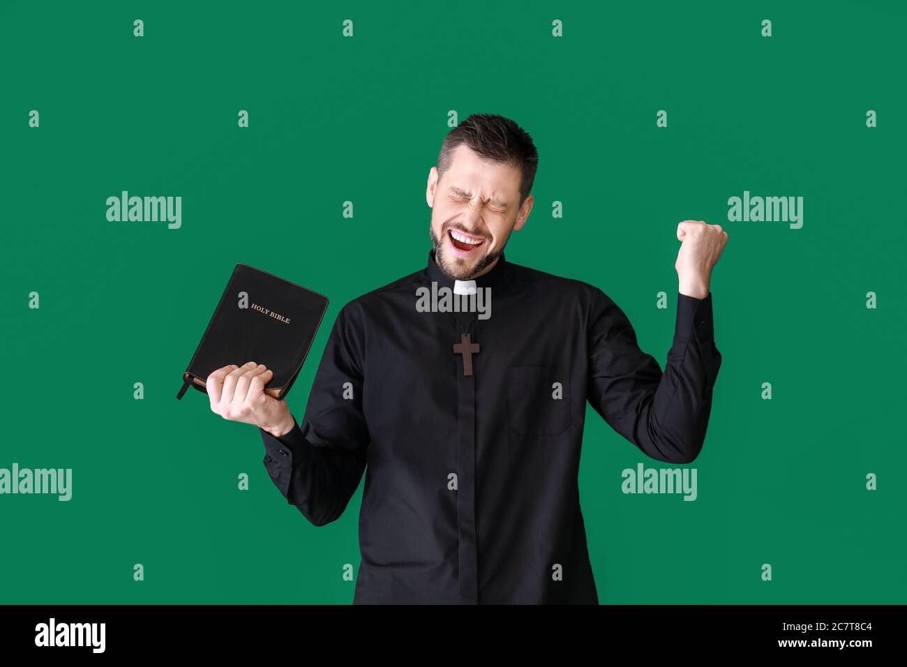 Happy priest with Bible on color background Stock Photo - Alamy