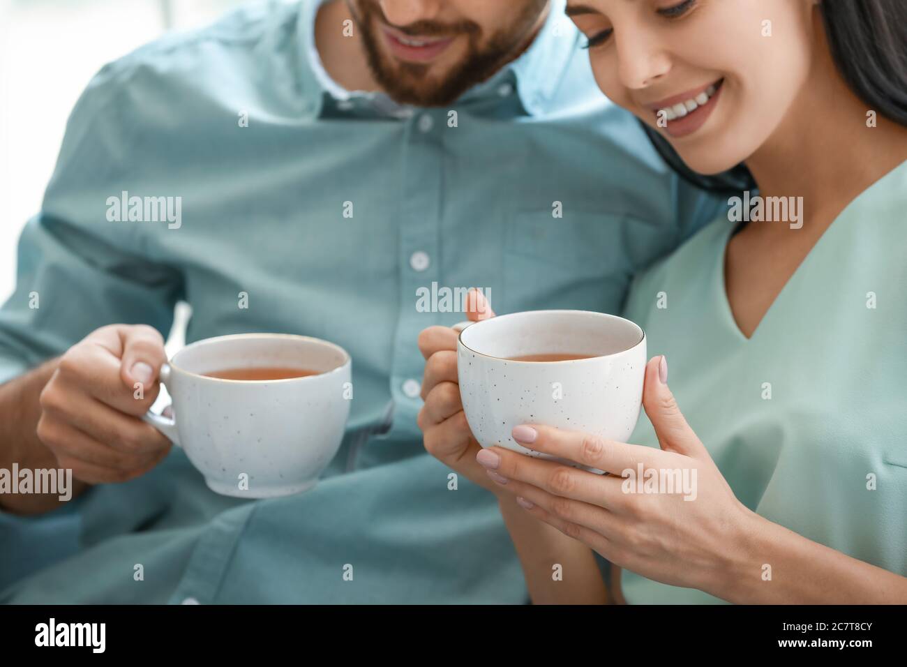 Happy young couple drinking tea at home Stock Photo - Alamy