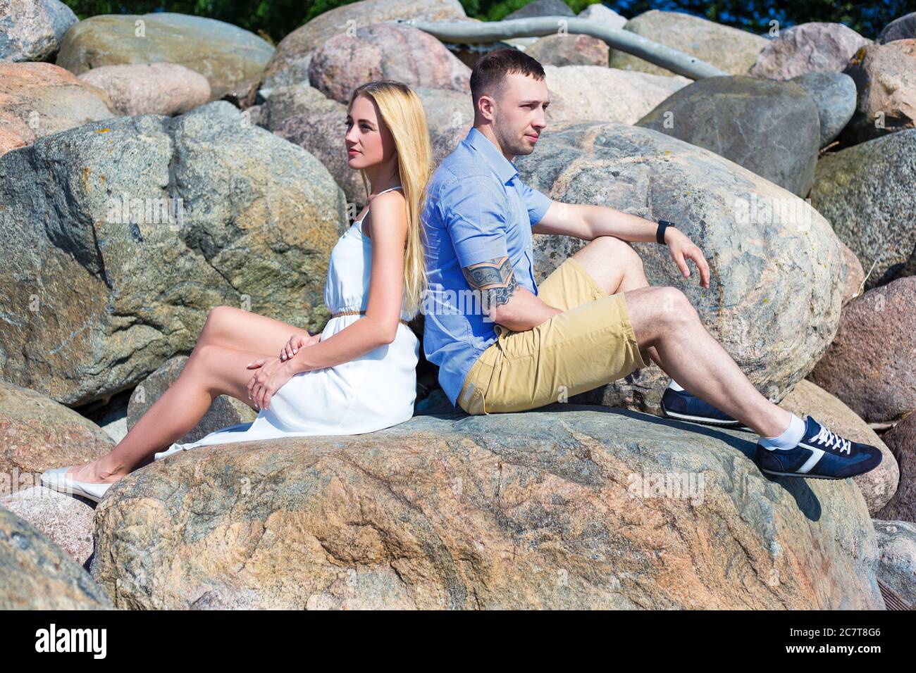 romantic portrait of happy couple in love sitting on big stone Stock ...