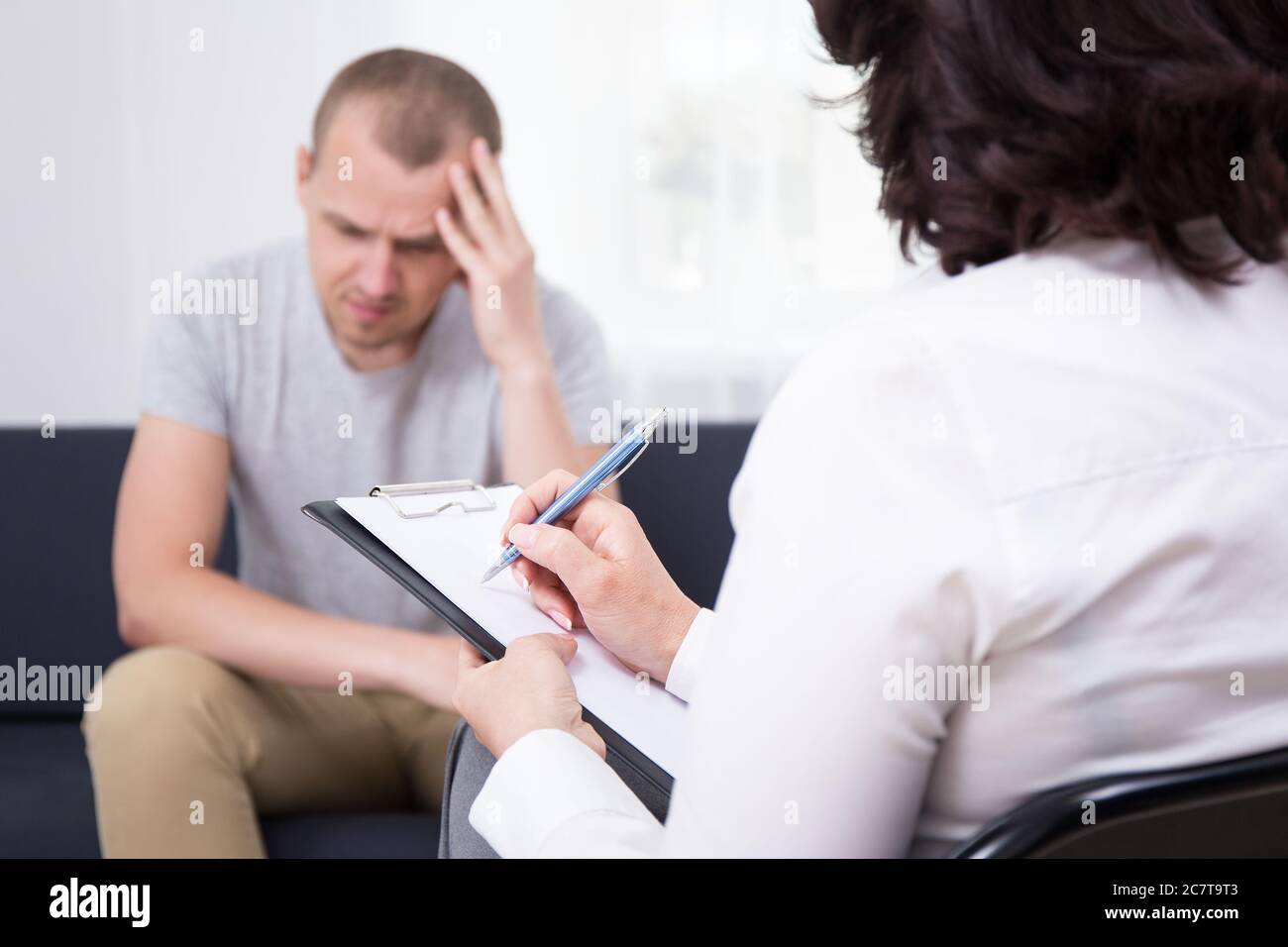 young sad man patient and female doctor in office Stock Photo - Alamy