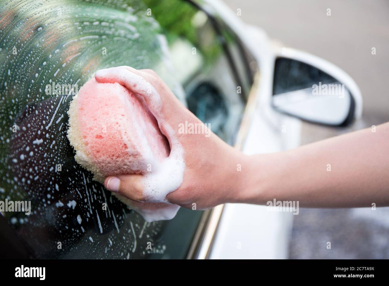 handle car wash concept - male hand washing car window with sponge ...