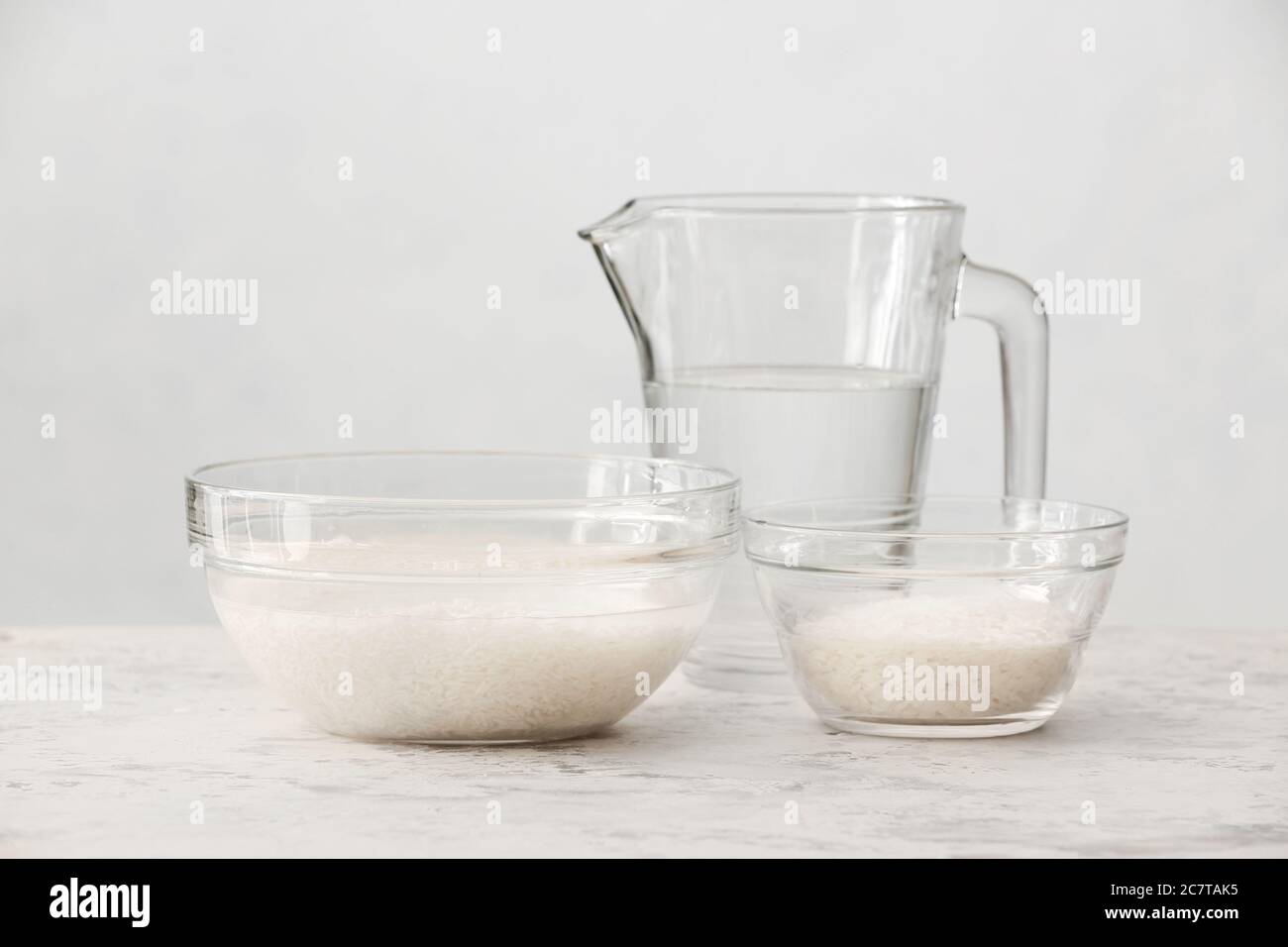 Bowls with rice and water in jug on table Stock Photo - Alamy