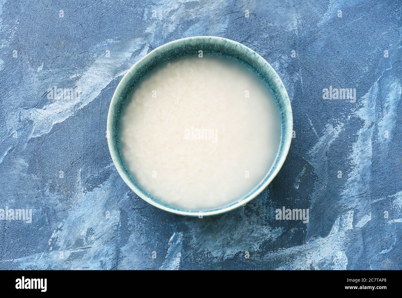 Bowl of rice water on color background Stock Photo - Alamy
