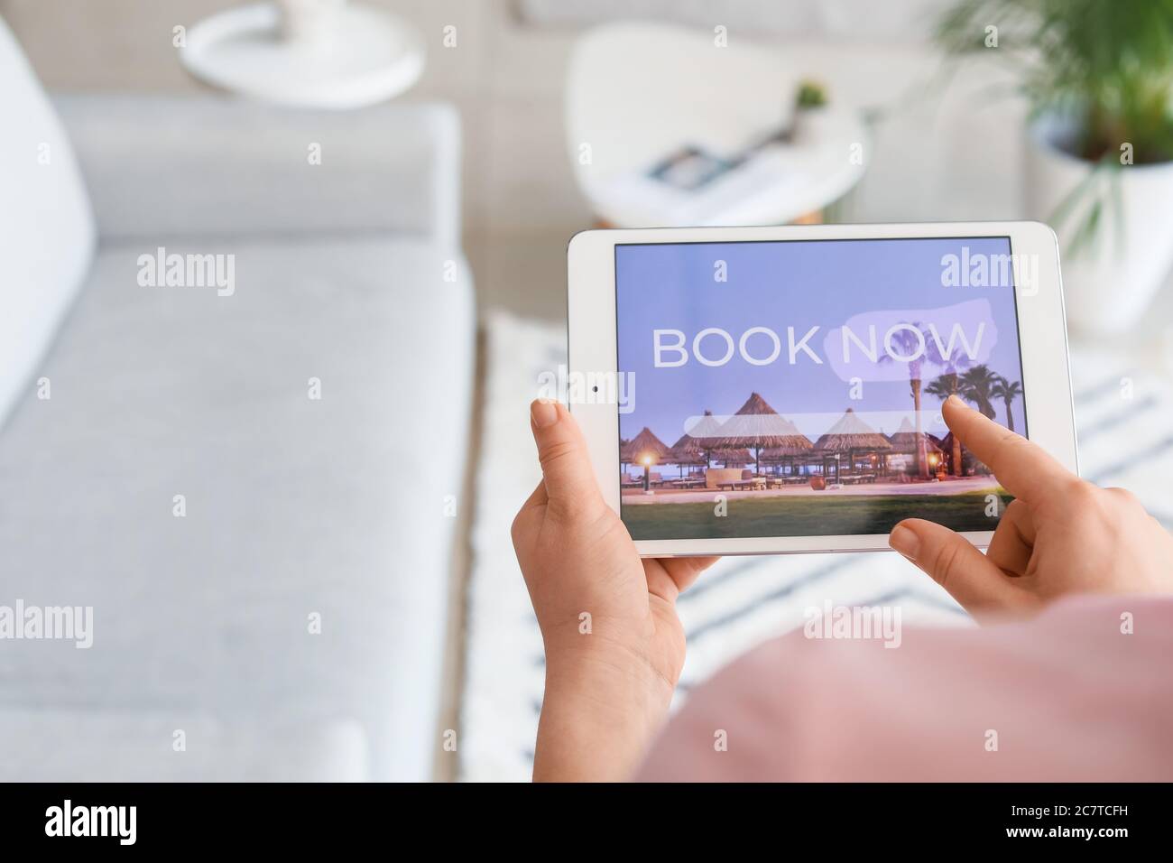 Woman with tablet computer booking tickets online at home Stock Photo ...